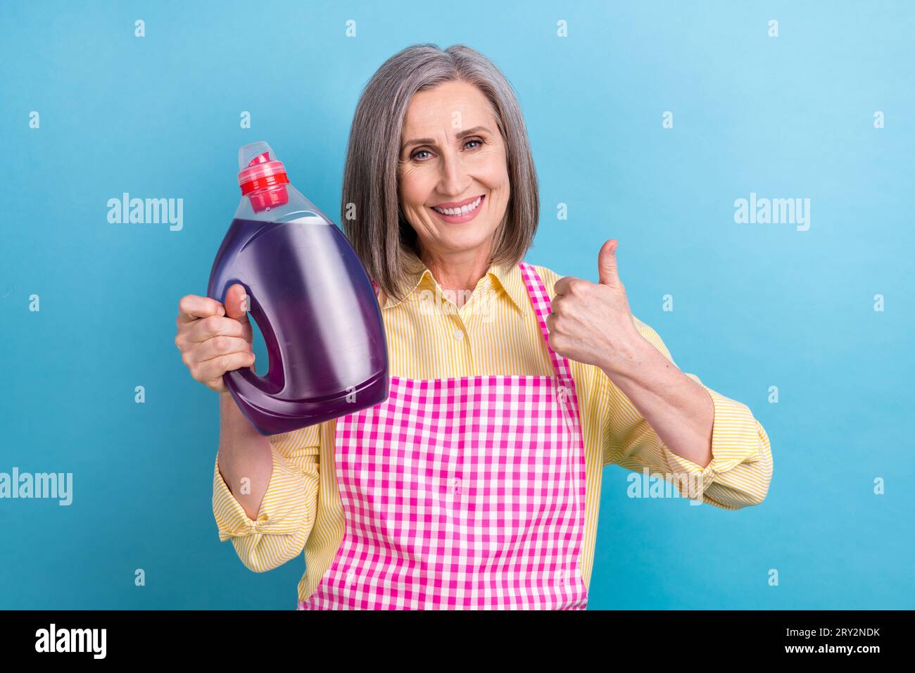 Photo of charming cheerful lady hold laundry detergent bottle ...
