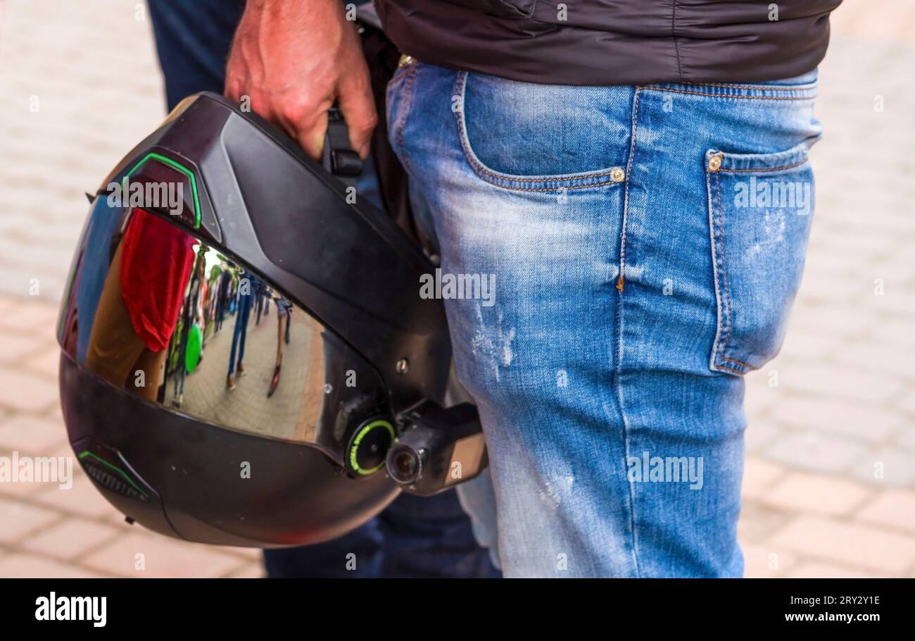 The man holds a motorcycle helmet in hand. Closeup picture of a Brutal ...