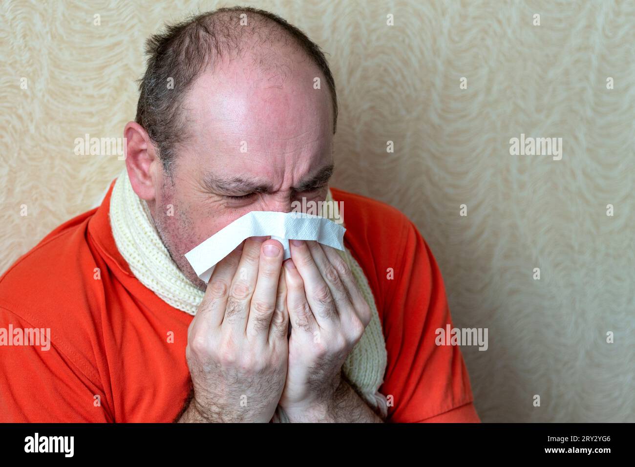 Sick male sneezes. The patient holds a handkerchief, a paper napkin at ...