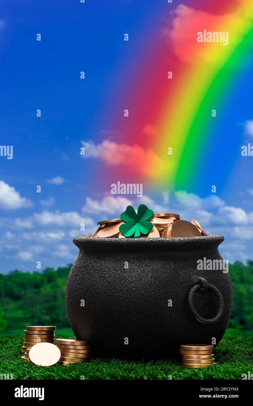 A black kettle pot full of gold coins and a single four leaf clover on ...