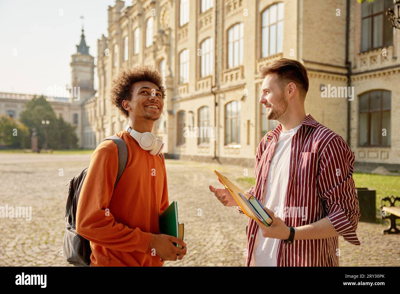 Happy positive male students talking together sharing expression Stock ...