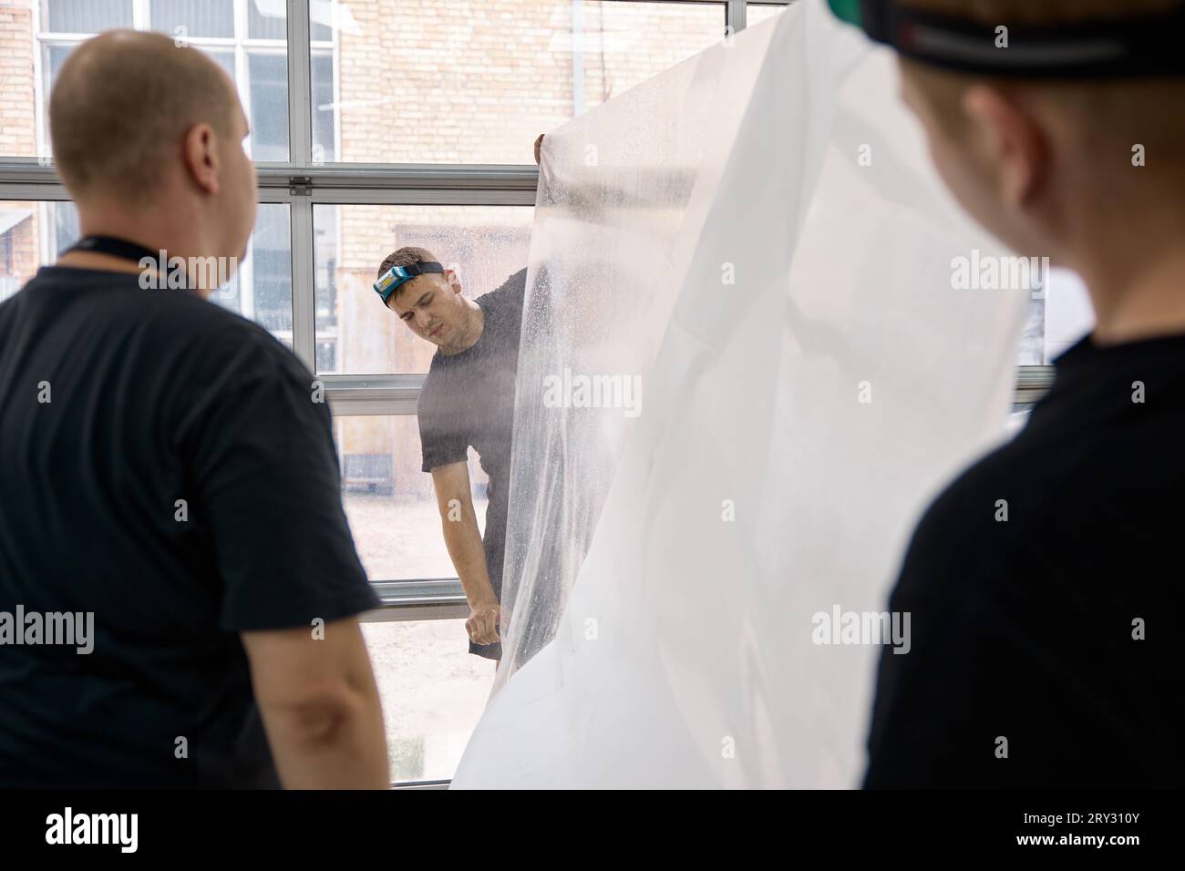 Car service worker team preparing armored protective film for ...