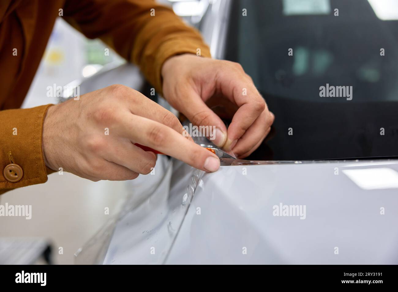 Protection film applying process in car garage Stock Photo - Alamy