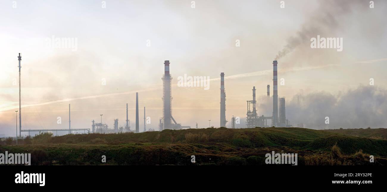 Panorama of an old oil refinery at dawn (first rays of the morning sun ...