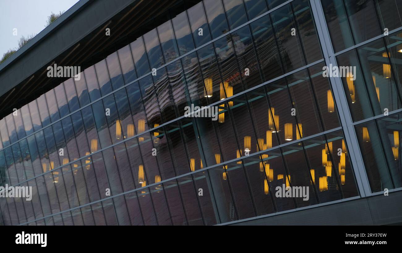 Modern glass building with lanterns inside and the reflection of a big ...