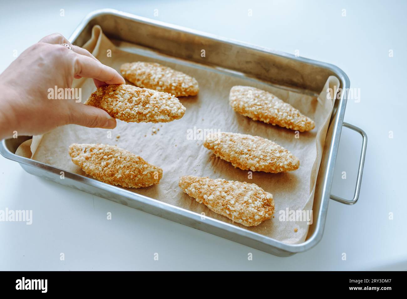 Raw frozen breaded chicken pieces on a baking sheet Stock Photo - Alamy
