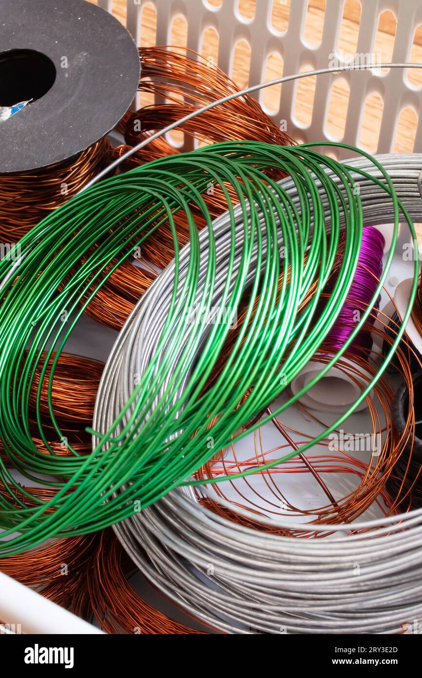 Copper wire coils in a plastic basket close up Stock Photo - Alamy