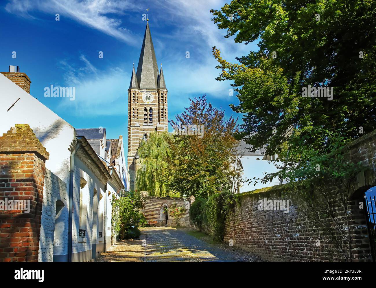 Idyllic narrow old alley in small Dutch village with medieval church ...