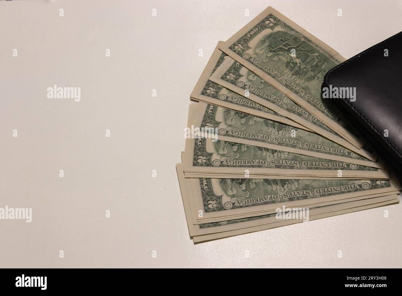 Photo of two dollar bills on white background with copy space next to a ...