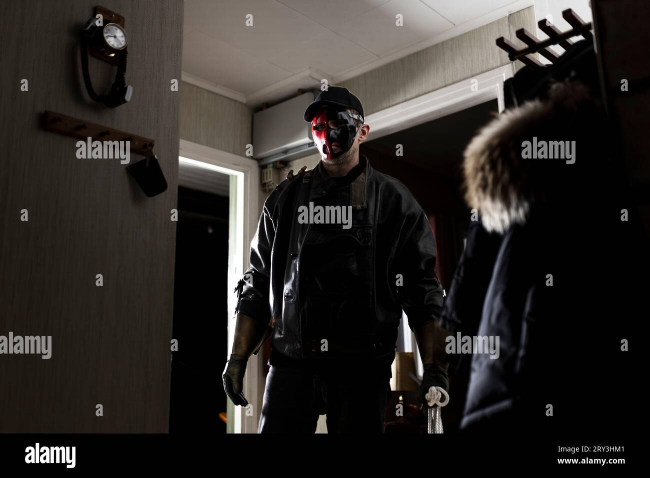 Demon wearing mask standing by doorway in cabin Stock Photo - Alamy