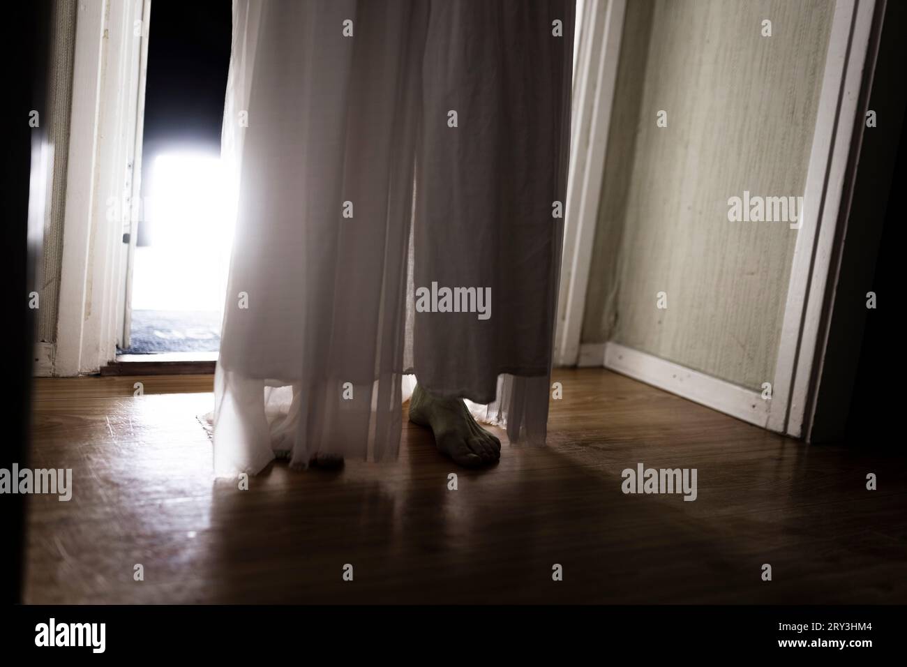 Low section of ghost standing at doorway in cabin Stock Photo - Alamy