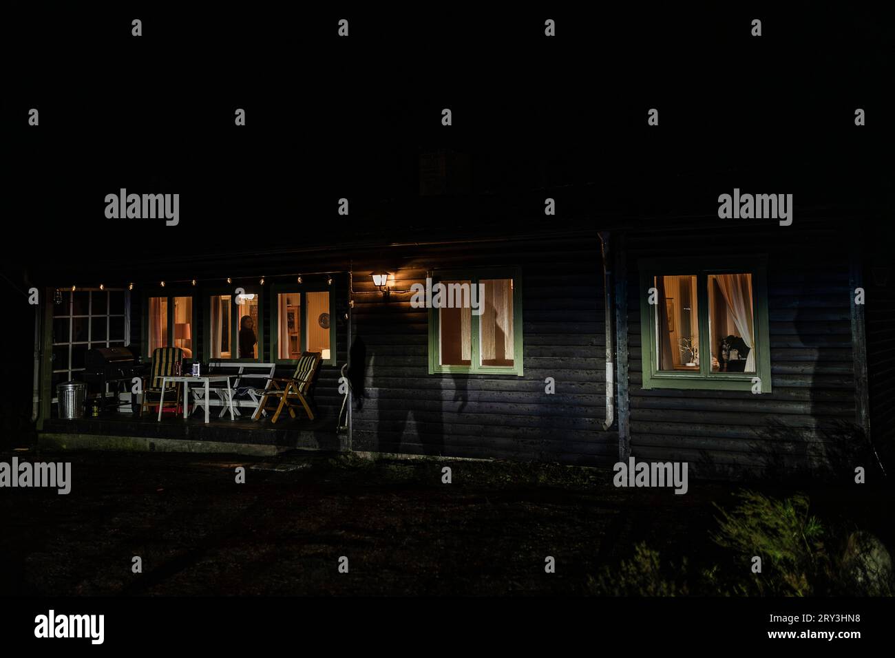 Shadow of demon on illuminated cabin at night Stock Photo - Alamy