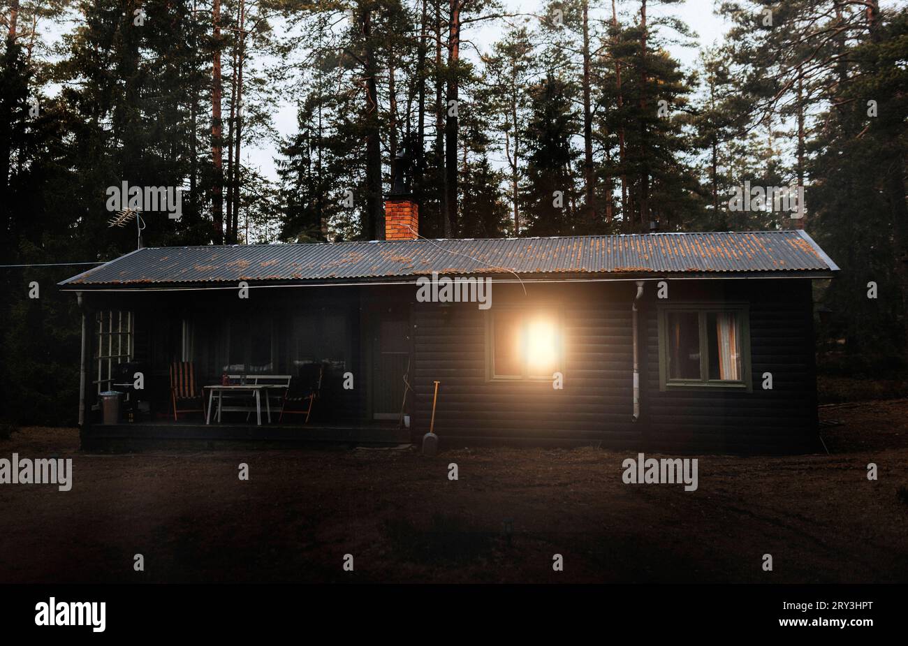 Exterior of log cabin with trees in background at sunset Stock Photo ...