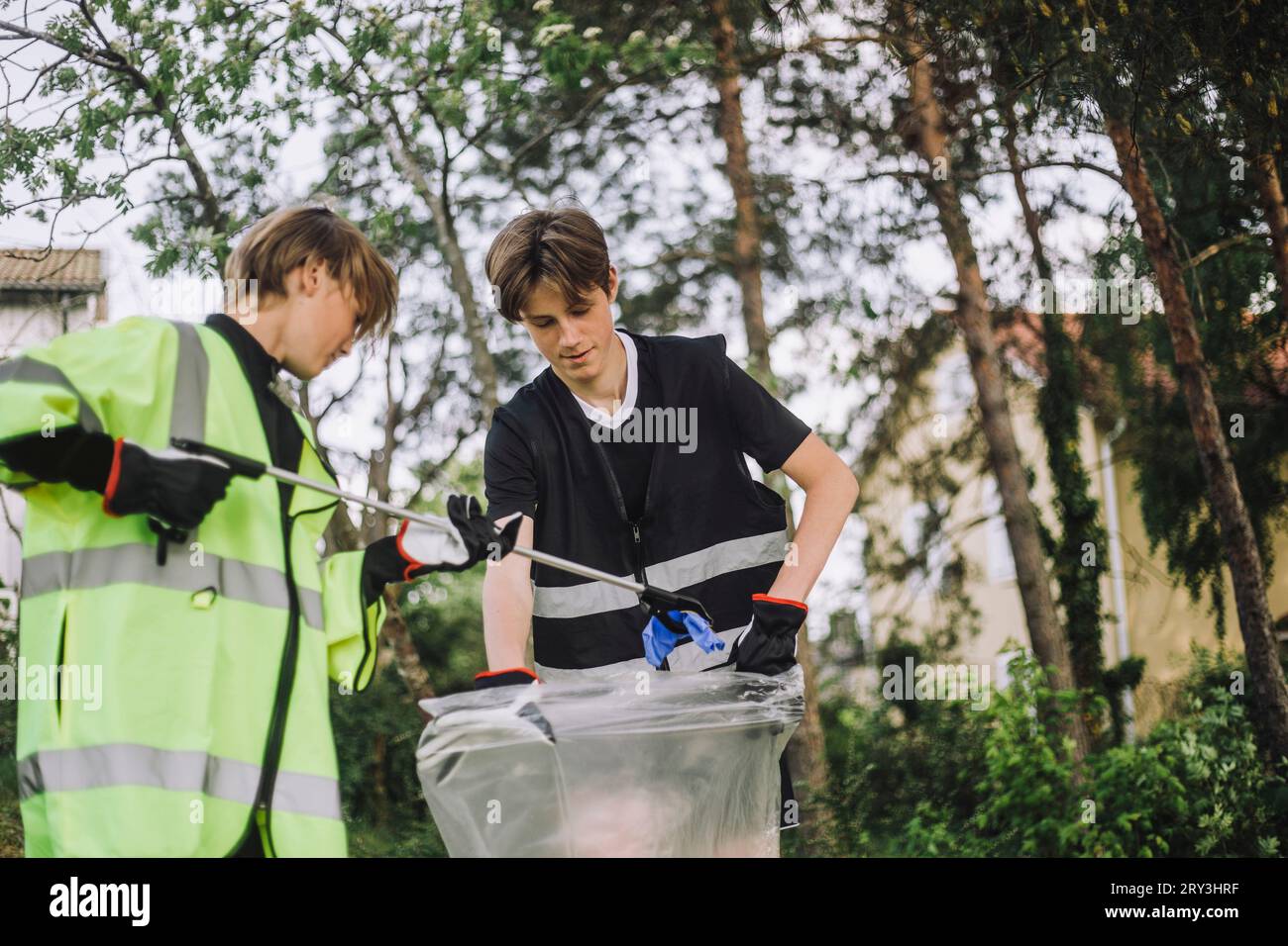 Boys collecting plastic in garbage bag Stock Photo - Alamy