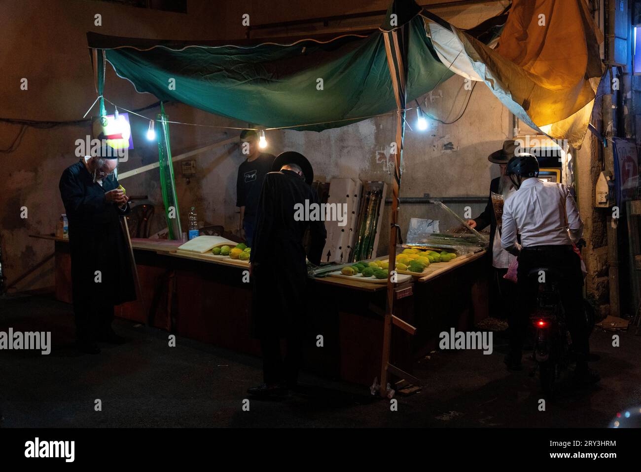 Ultra-Orthodox Jewish men inspect an etrog, a citrus fruit, to ...