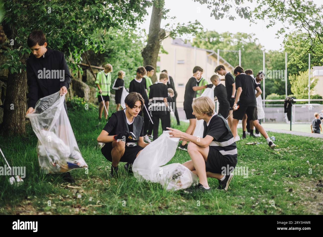 Boys collecting garbage in plastic bags Stock Photo - Alamy