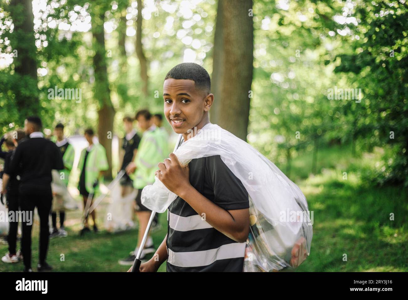 Portrait of boy with garbage bag over shoulder Stock Photo - Alamy