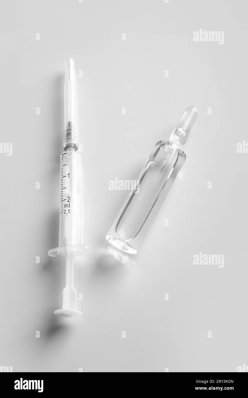 Medical ampule with syringe on light background Stock Photo - Alamy