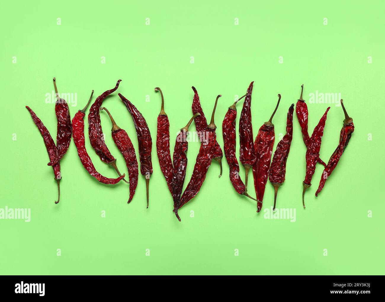 Dry hot chili peppers on pale green background Stock Photo - Alamy