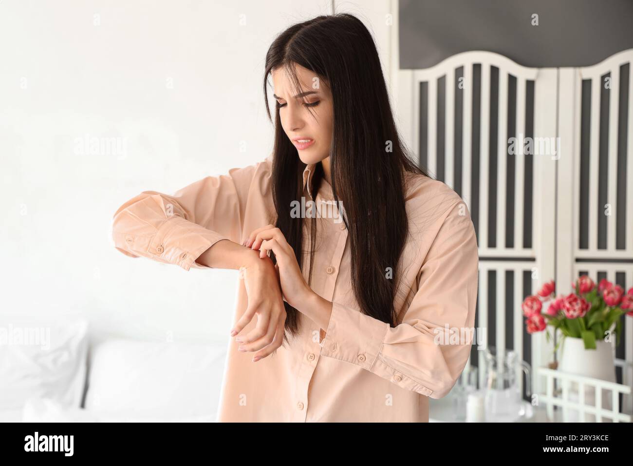 Allergic young woman scratching in bedroom Stock Photo - Alamy