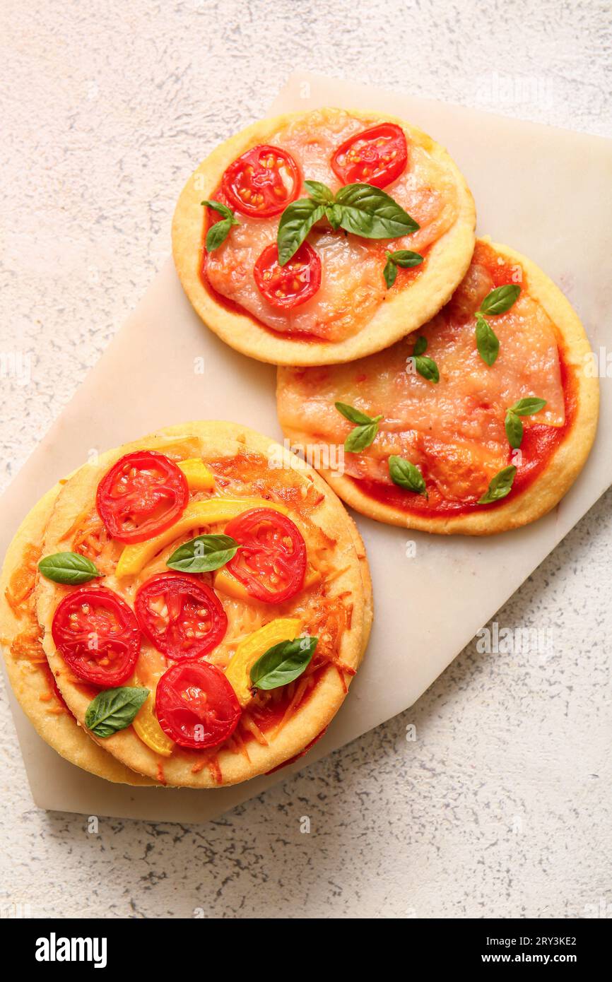 Board with different tasty mini pizzas on white background Stock Photo ...