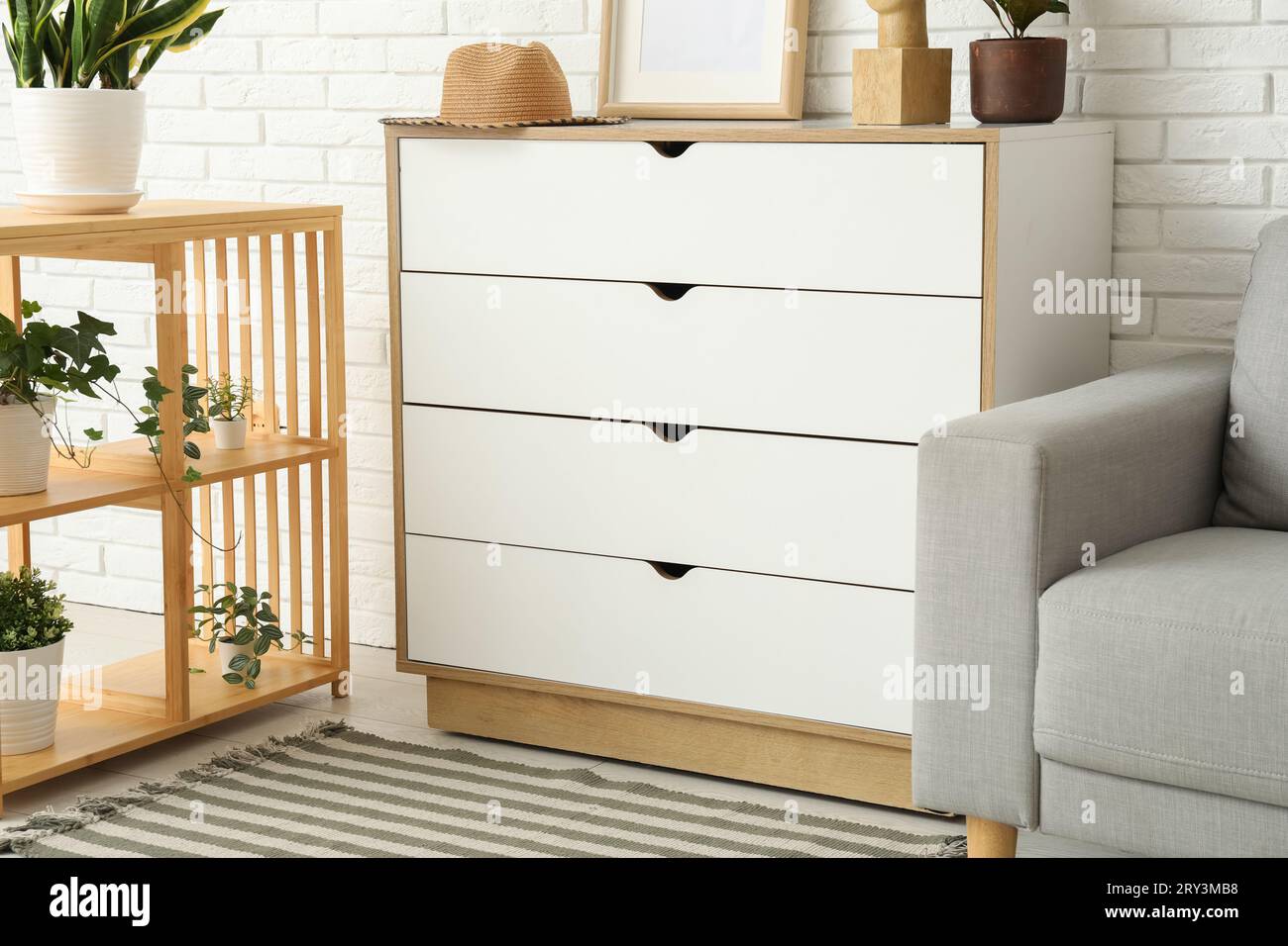 Interior of light living room with drawers, sofa and shelving unit ...