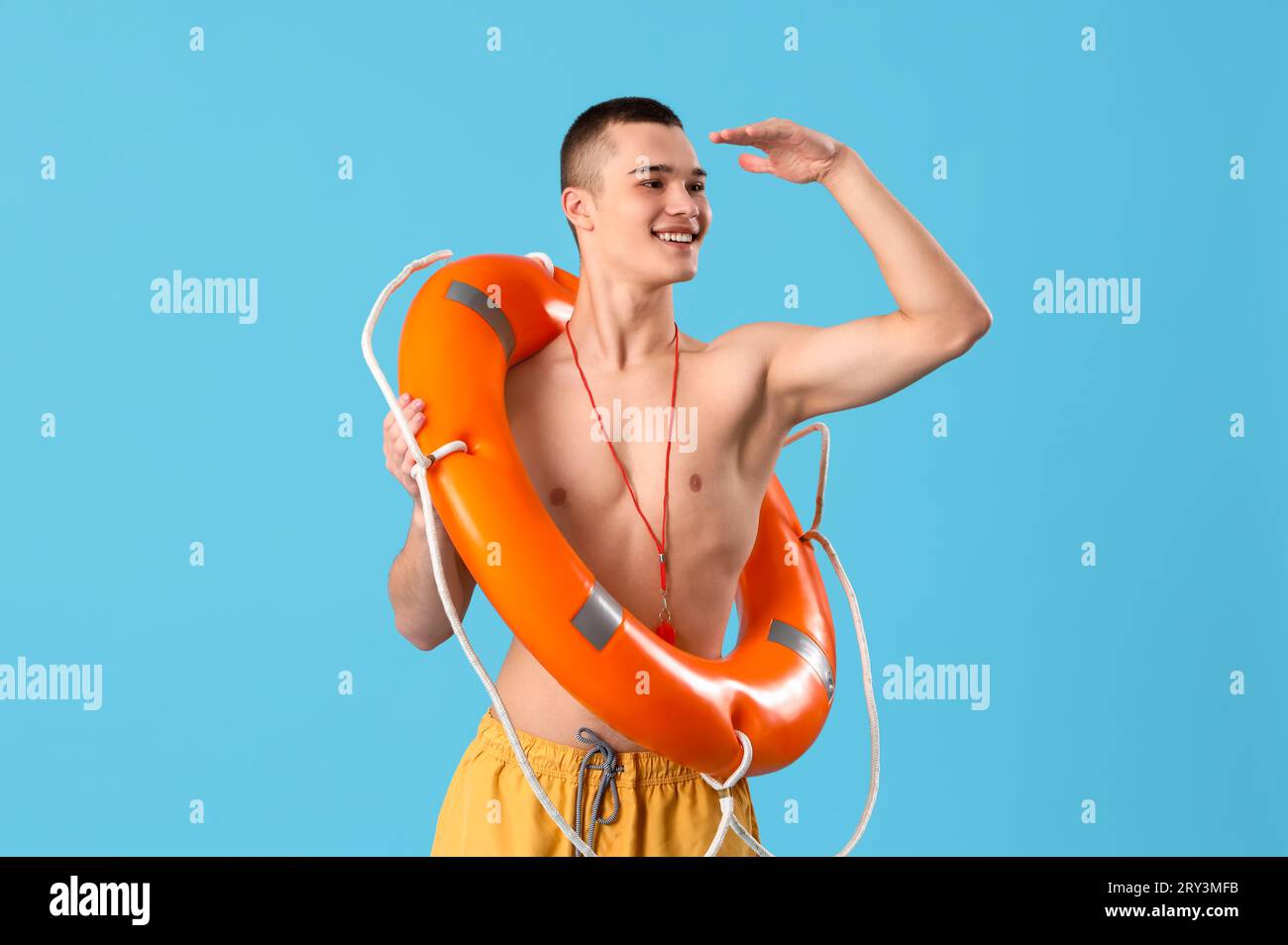 Male lifeguard with ring buoy on blue background Stock Photo - Alamy