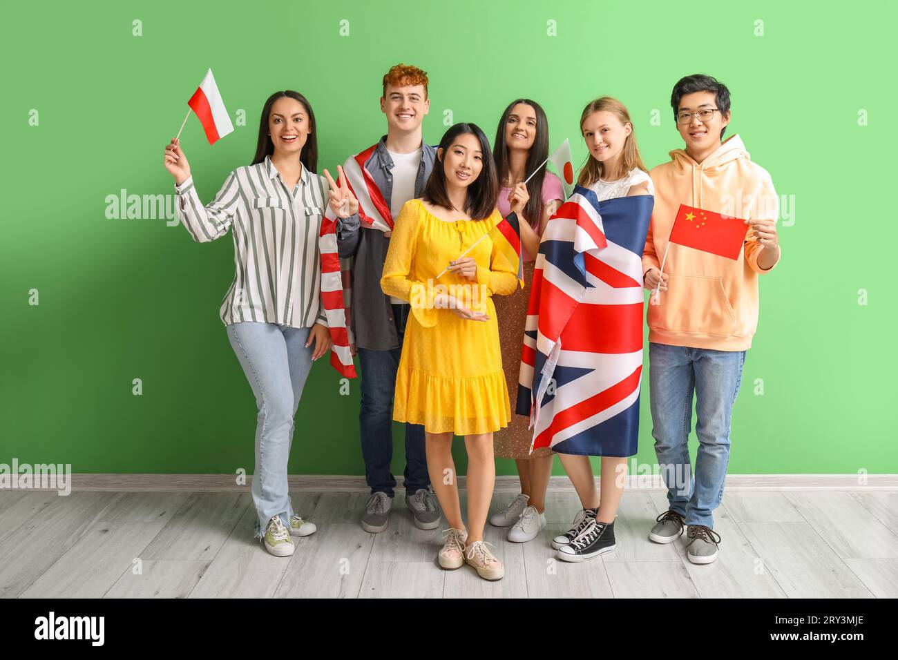 Young students of language school with flags near green wall Stock ...