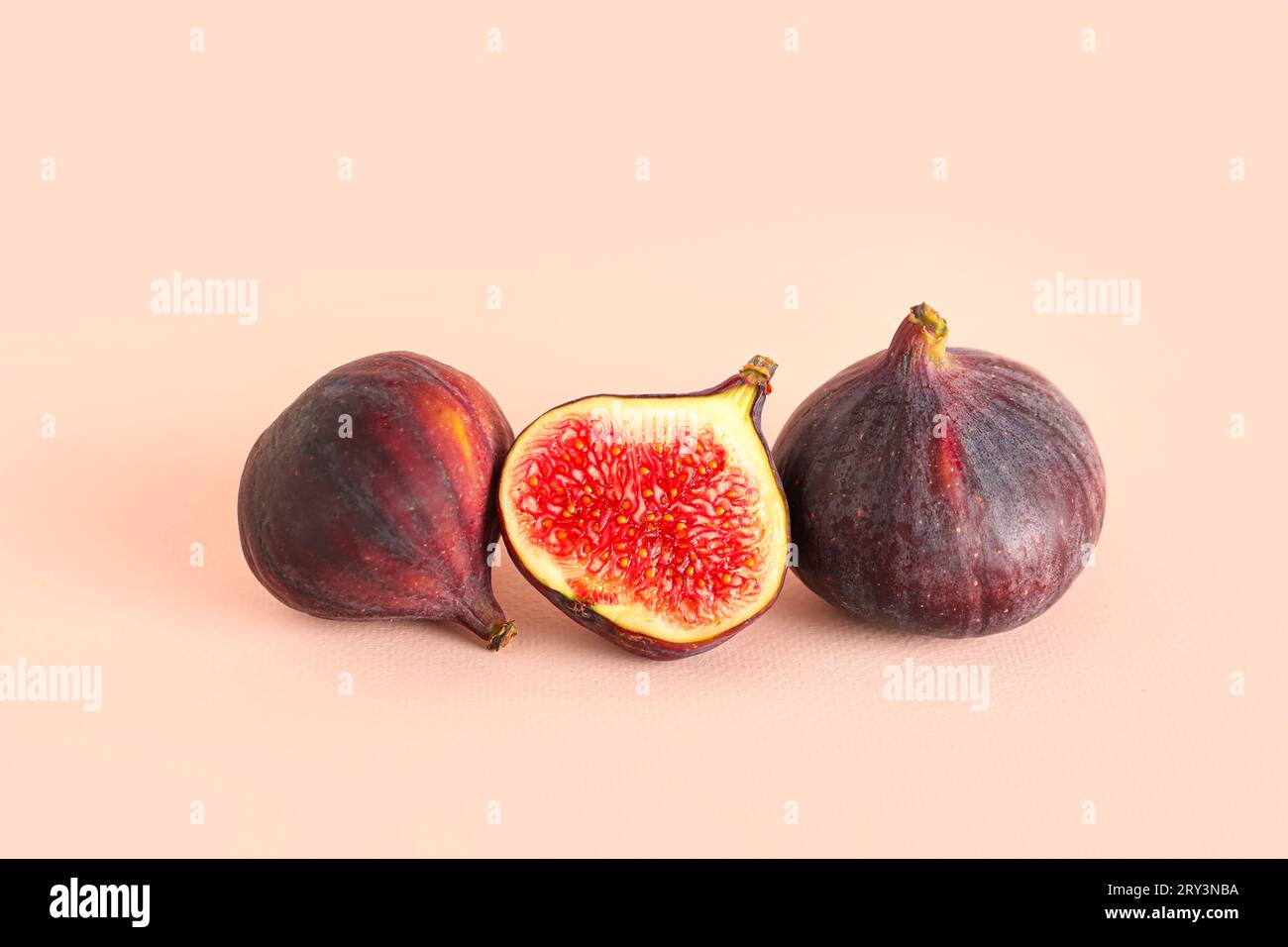 Fresh juicy cut figs on pale pink background Stock Photo - Alamy