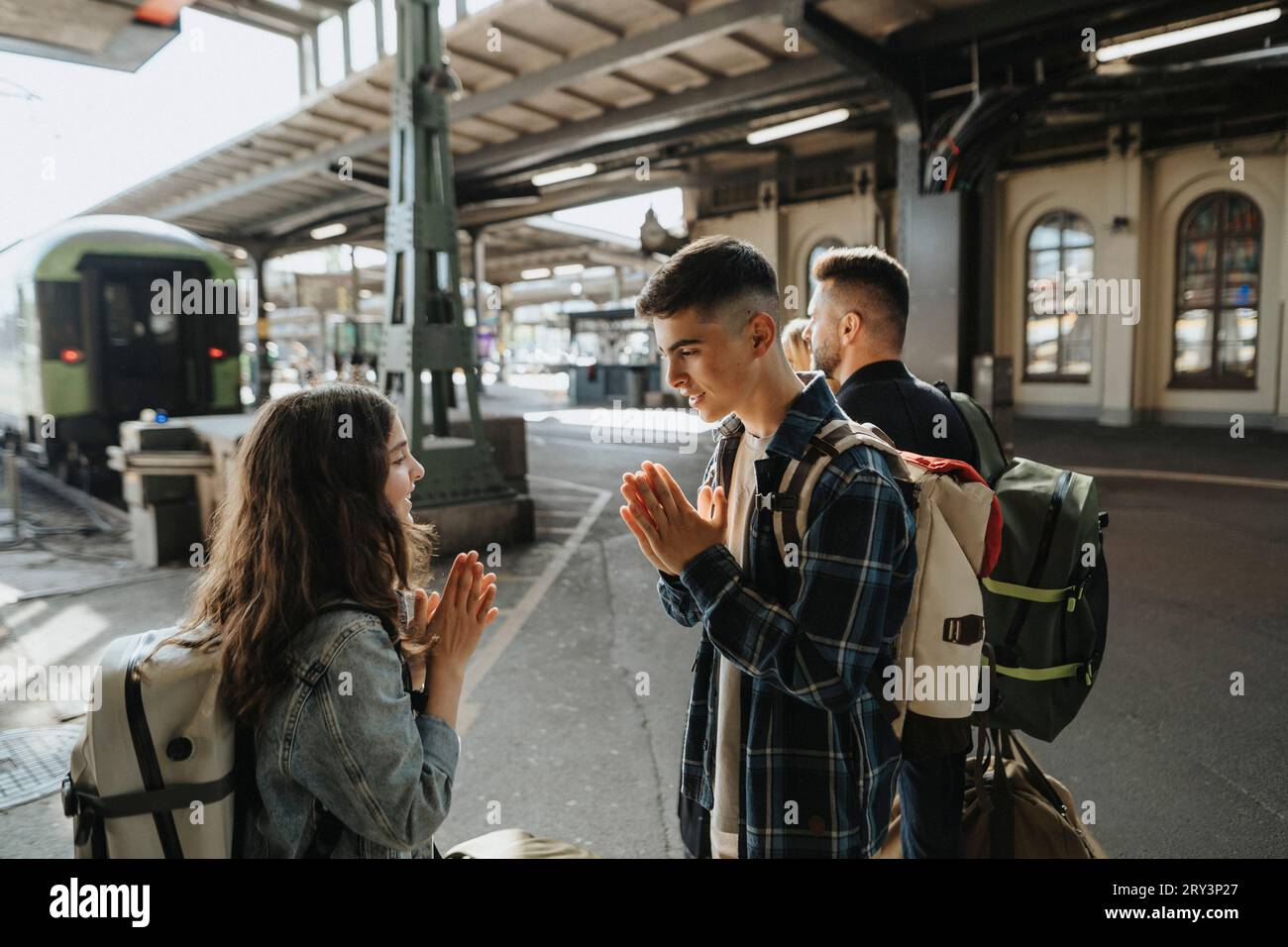 Brother playing leisure game with sister while waiting for train at ...