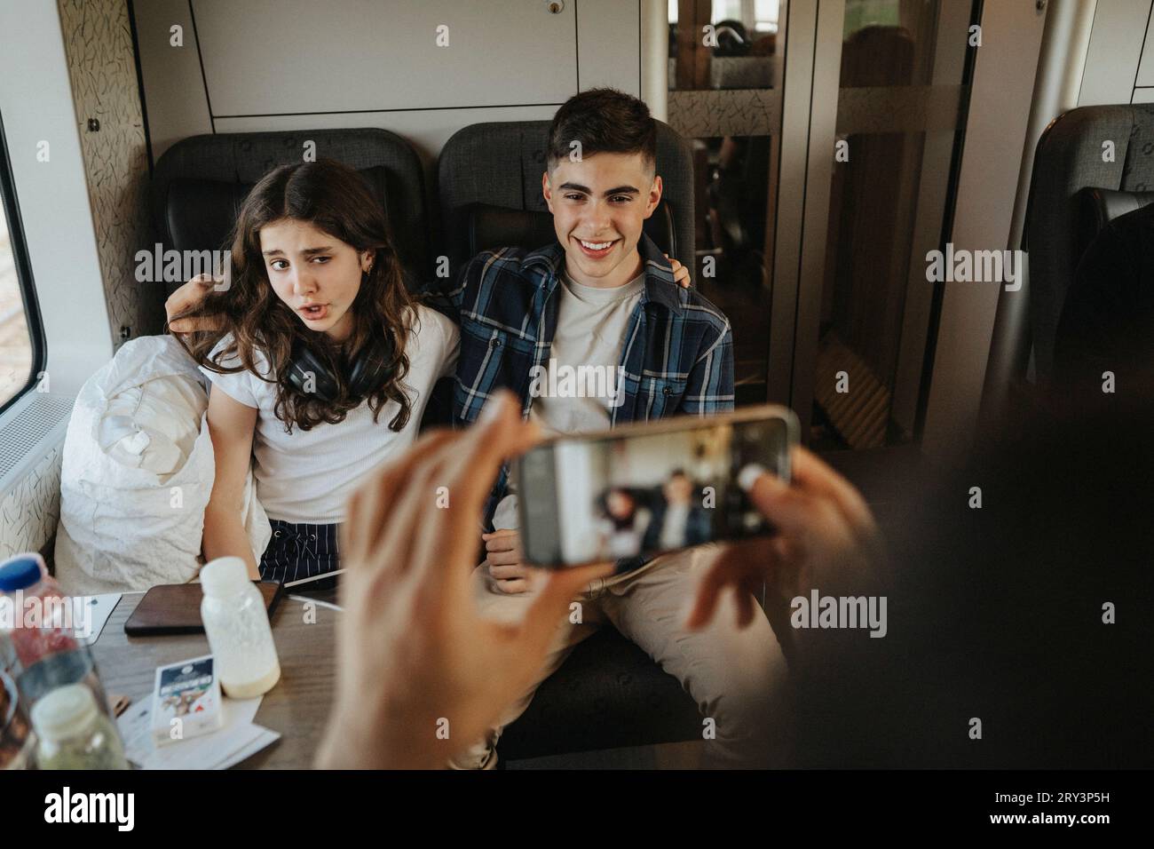 Father taking picture of son and daughter making faces while sitting in ...