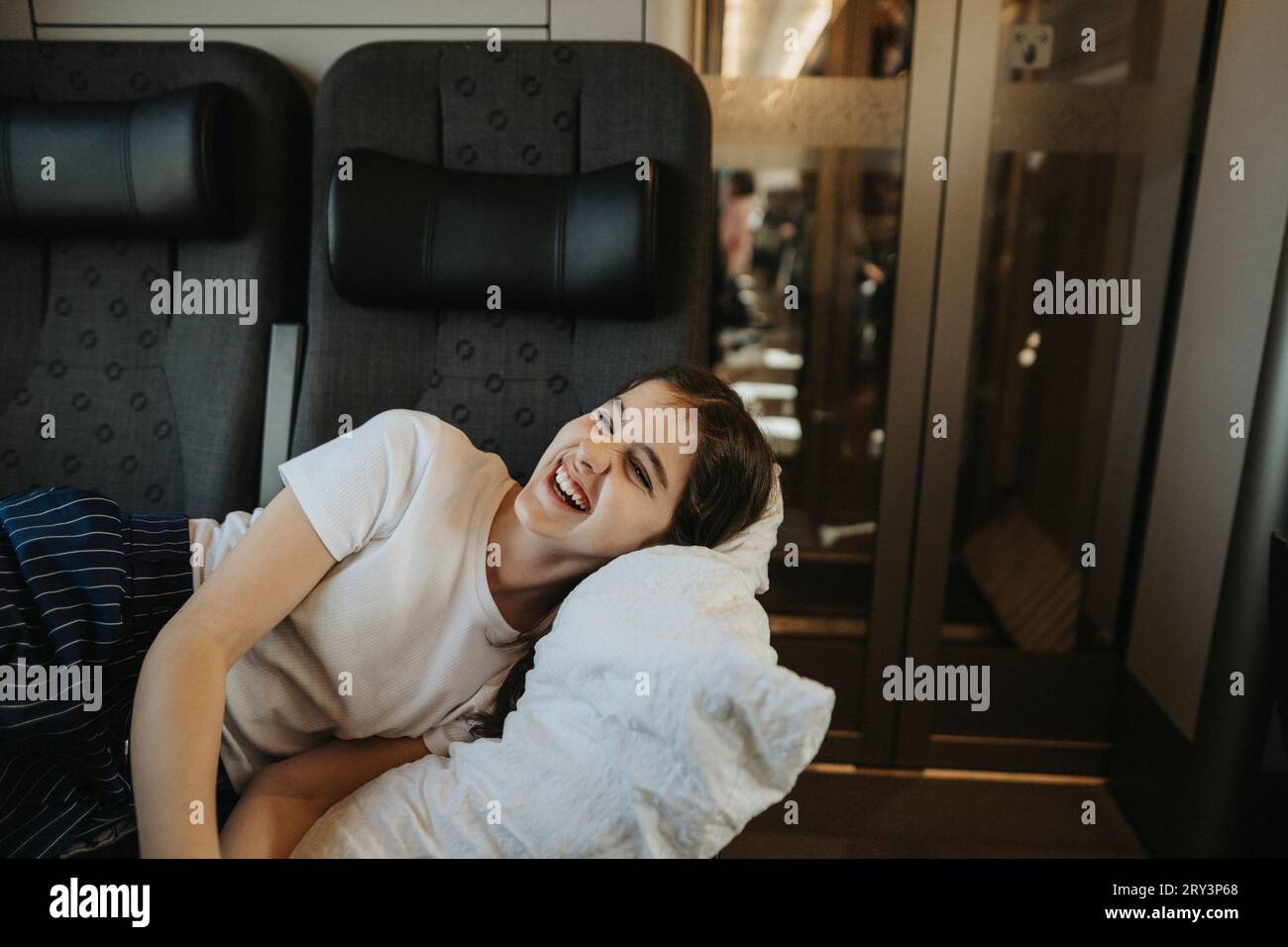 Happy girl laughing while resting on seat in train Stock Photo - Alamy