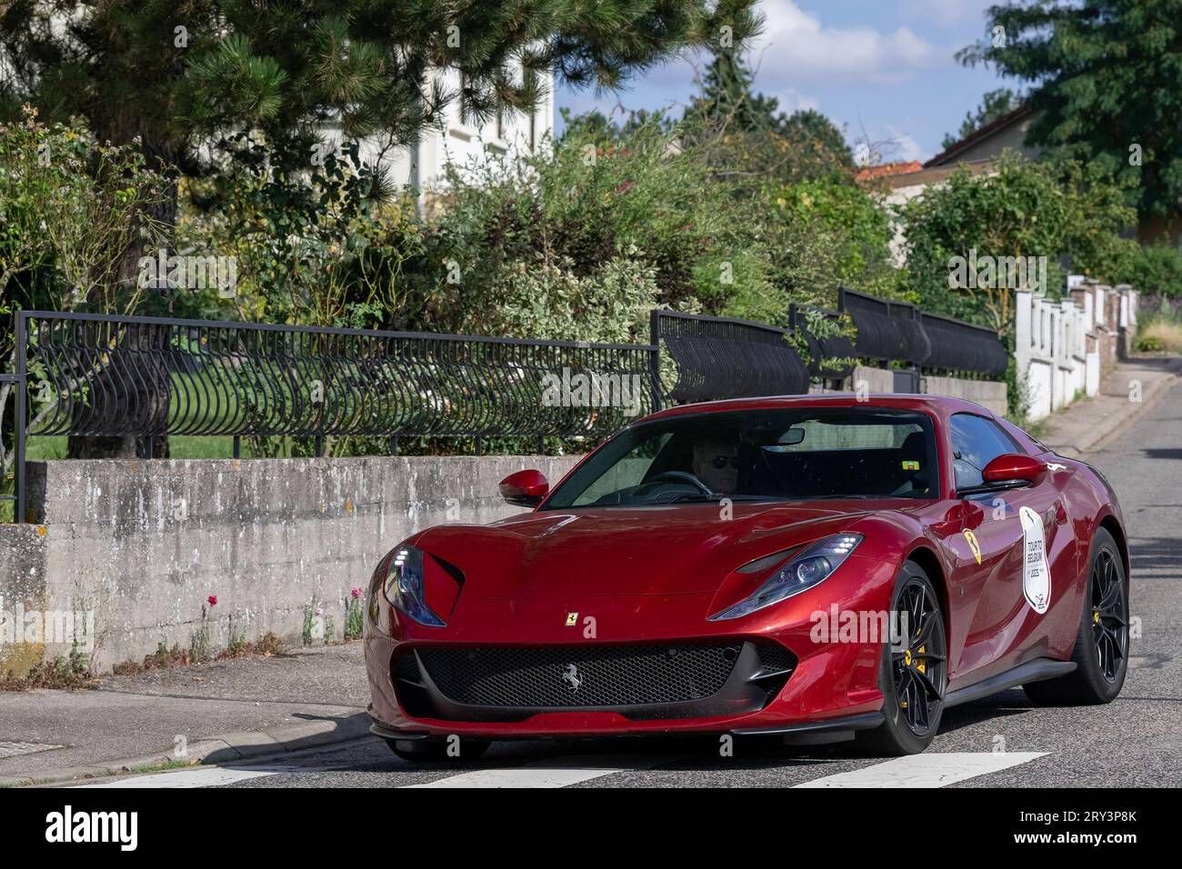 Burgundy Ferrari 812 GTS driving on the road Stock Photo - Alamy