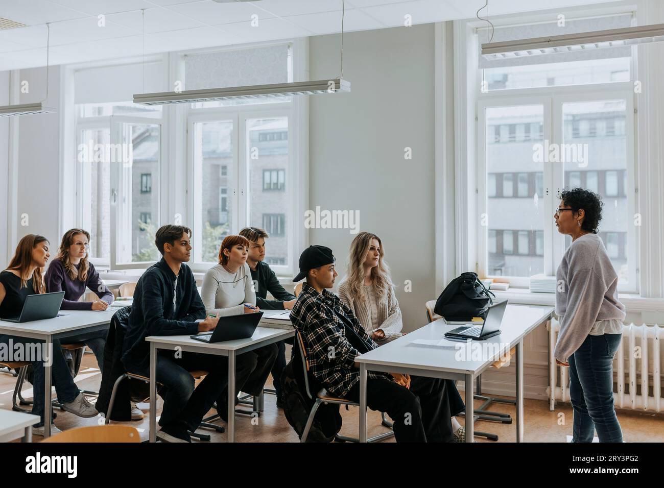 Teacher teaching multiracial students in classroom Stock Photo - Alamy