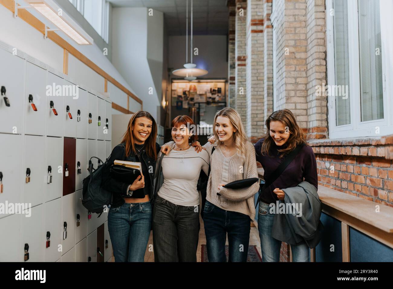 Happy female students walking in school corridor Stock Photo - Alamy