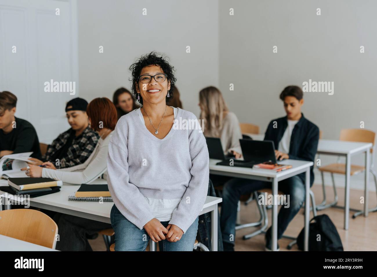Portrait happy professor sitting desk hi-res stock photography and ...