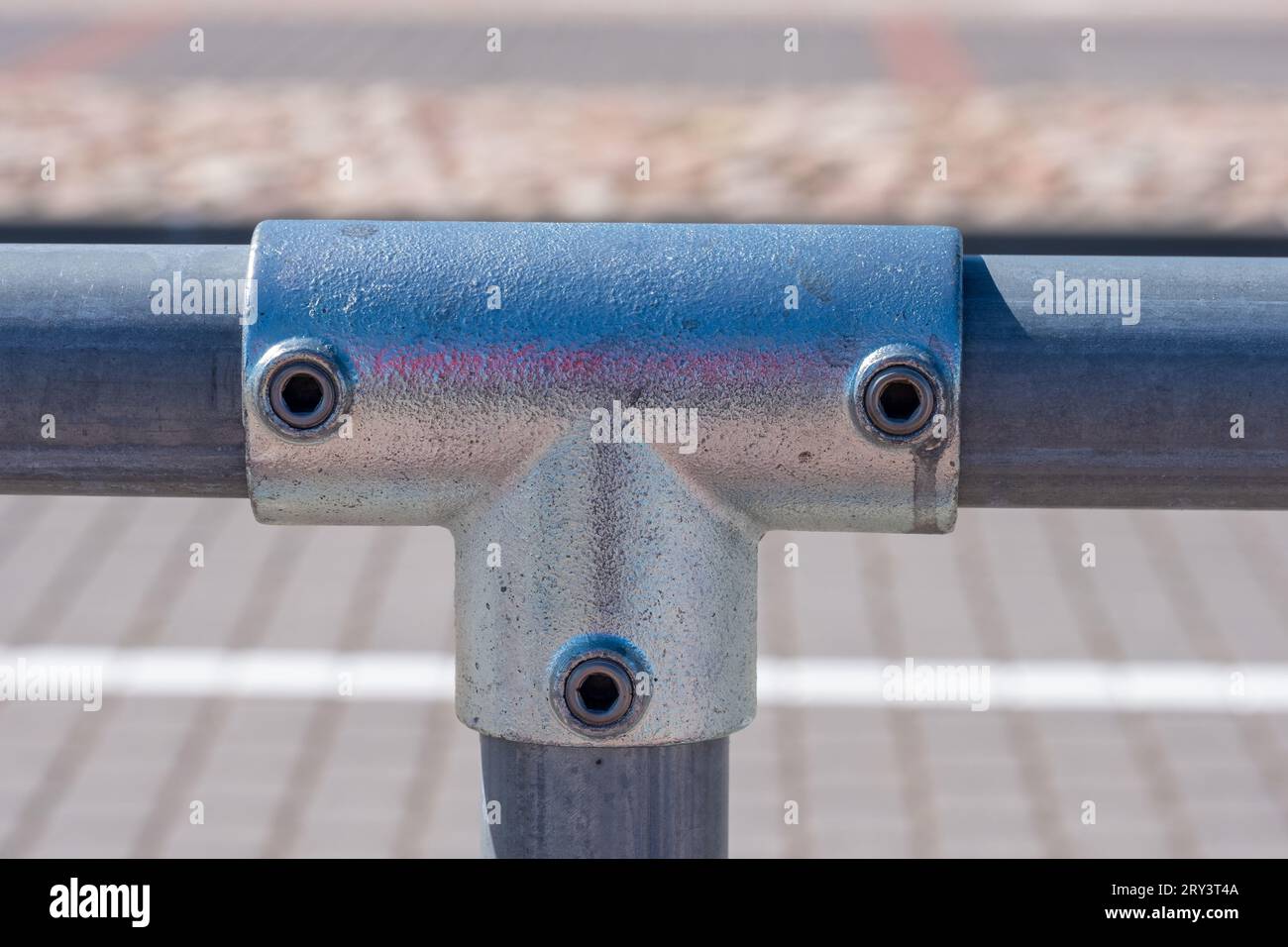 Metal pipe fastening with threads. In the background, a white stripe is ...