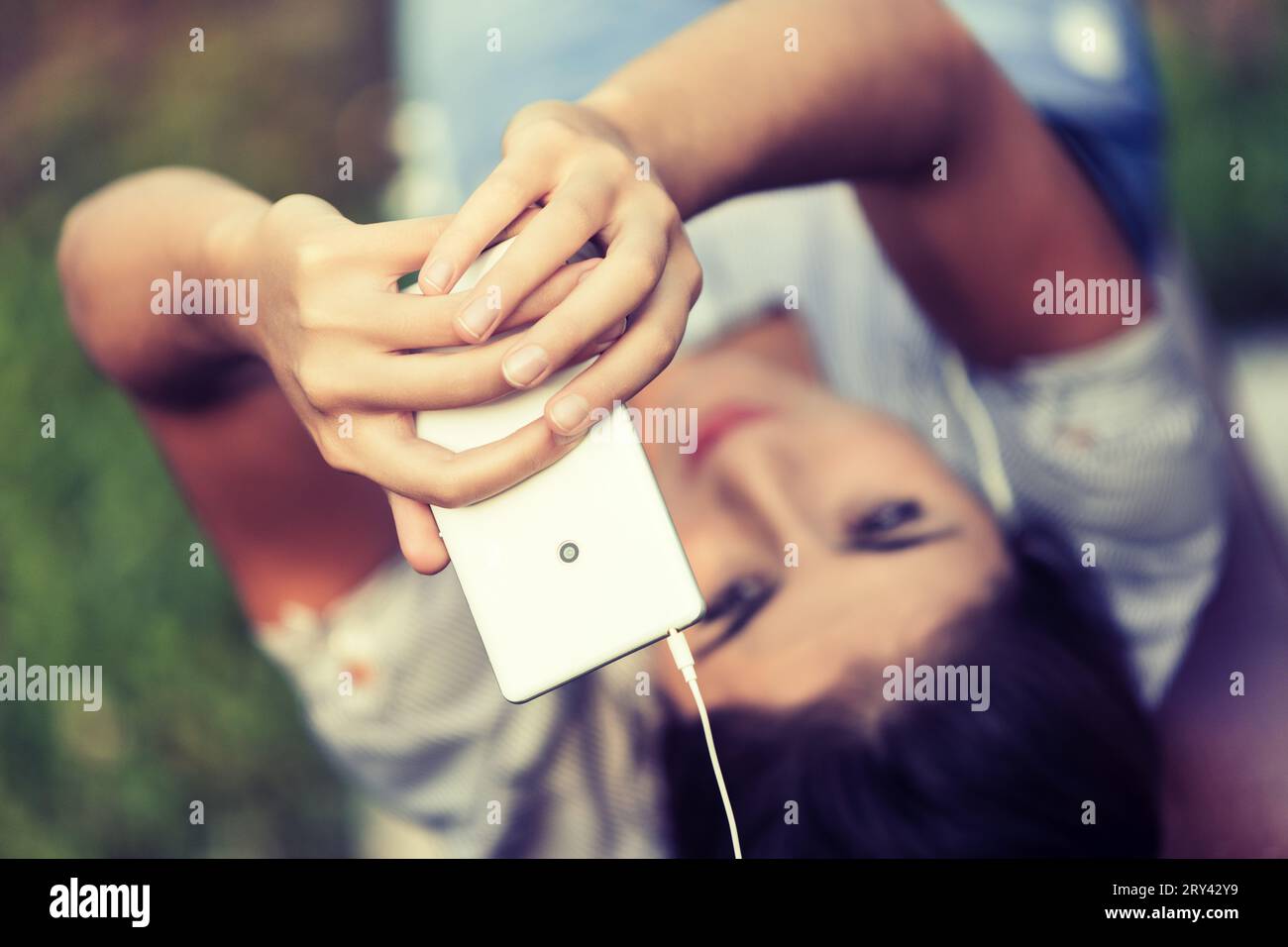 Outside, a young woman skillfully employs her smartphone for various ...