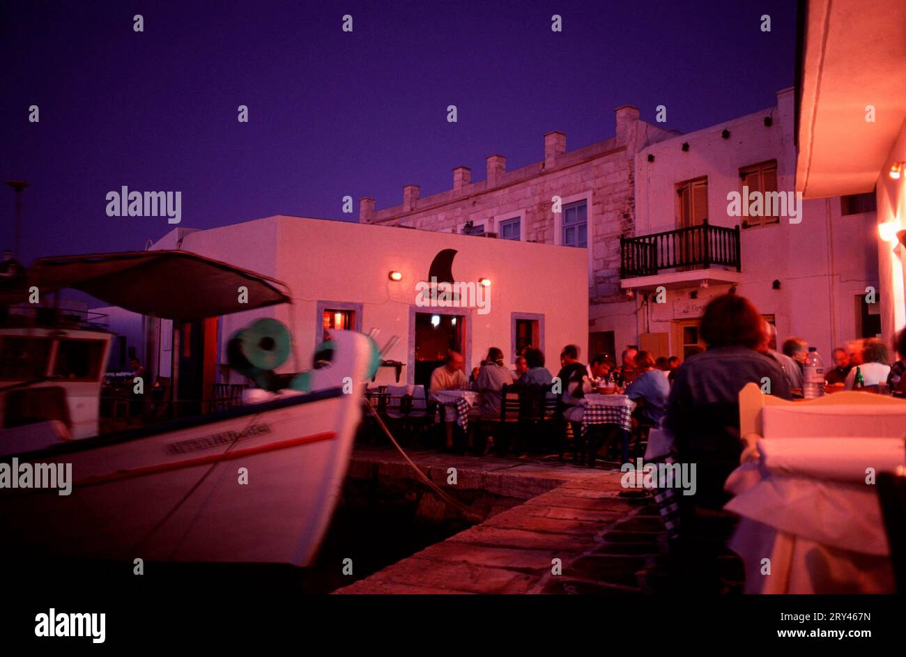Terrace of a restaurant and fishing boats in the old fishing harbour of ...