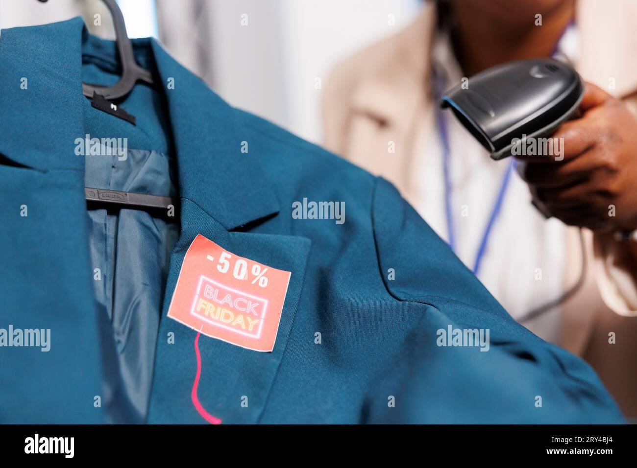 Female cashier holding barcode scanner scanning black Friday price tag ...