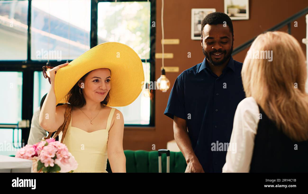 Hotel concierge welcoming people in reception lobby, doing check in ...