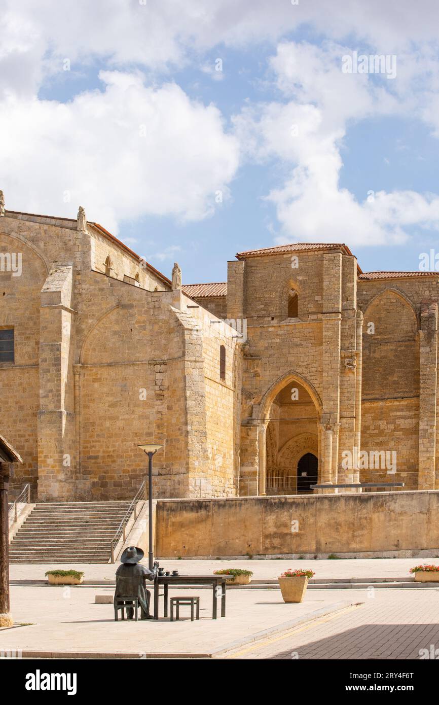Statue of a pilgrim sitting at a table on the Camino de Santiago ...