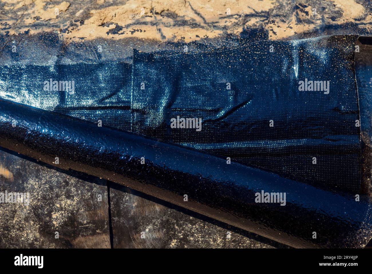 Type of insulation against corrosion of large metal pipe. Black pipe ...