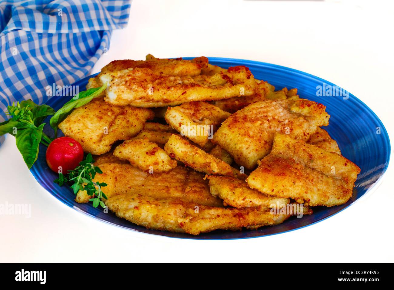 crispy fried fish pieces on o blue plate on white background, tasty ...