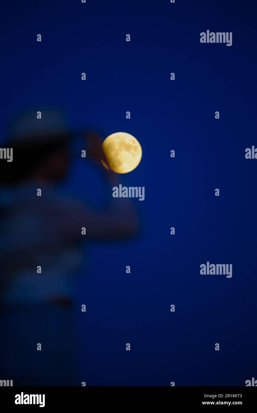 Barcelona/Spain The full moon appears over the city of Barcelona, Spain ...