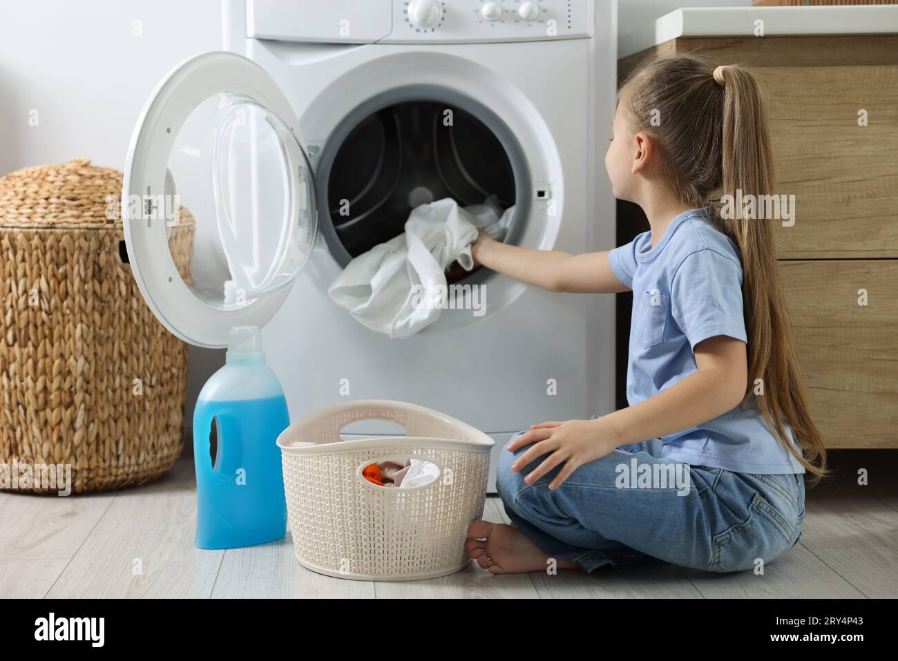 Child putting clothes washing machine hi-res stock photography and ...