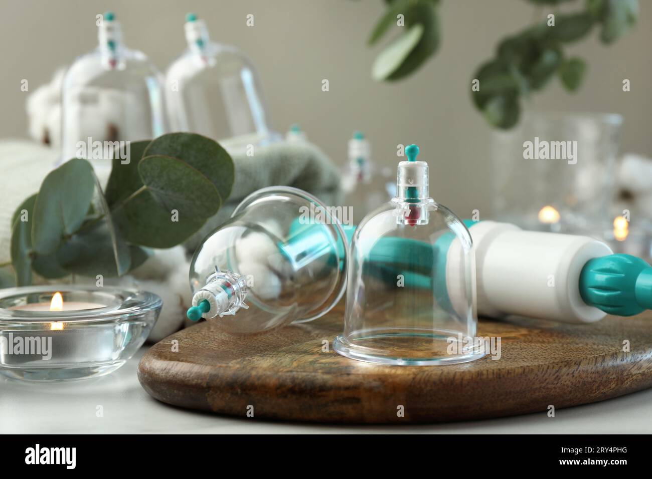 Plastic cups and hand pump on white table. Cupping therapy Stock Photo ...