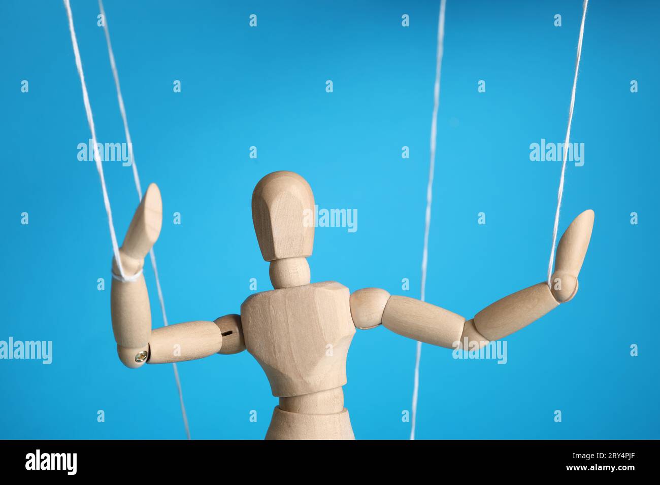 One wooden puppet with strings on light blue background Stock Photo - Alamy