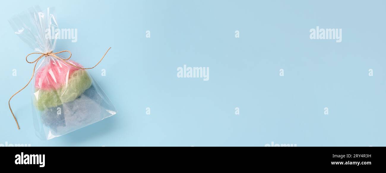 Packaged sweet cotton candy on light blue background, top view. Banner ...