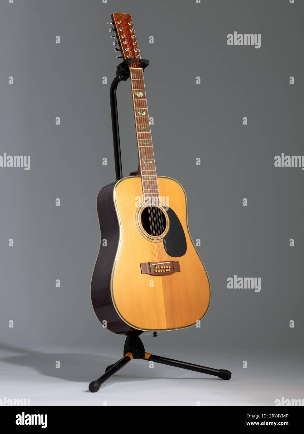 Joodee acoustic 12-string guitar on a stand, angled, on a grey ...